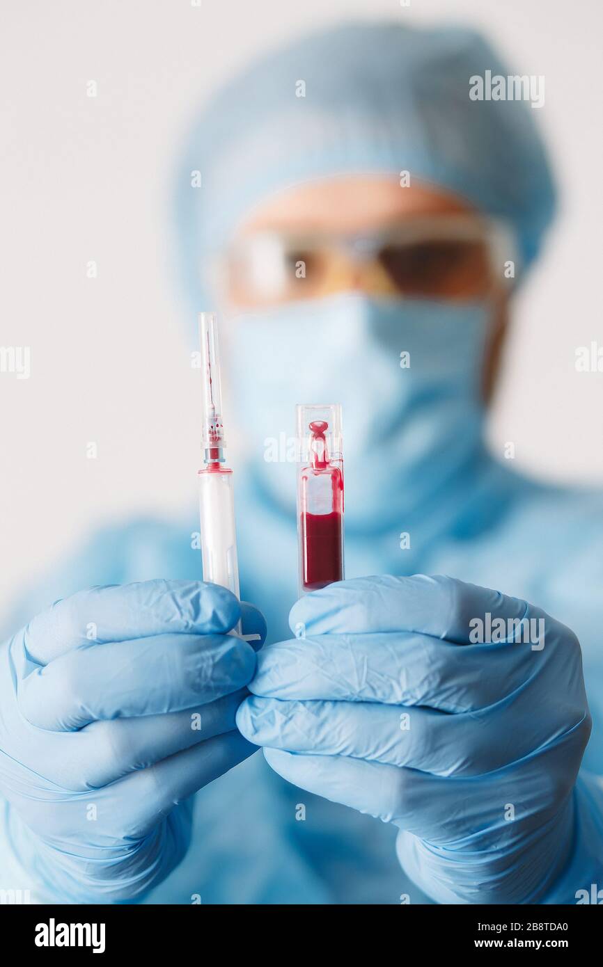 Close up of doctor hand holding syringe and blood sample. Medical ...