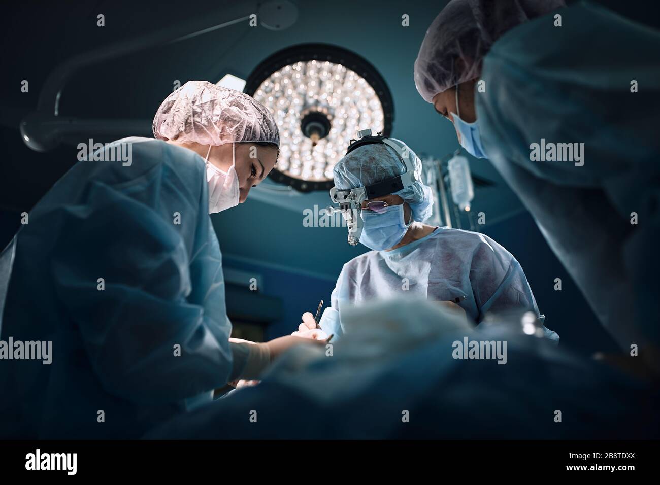 Medical team in the operating room, dark background. The theater of the ...