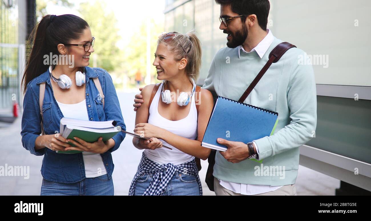 Group of happy college students studying at campus library together ...
