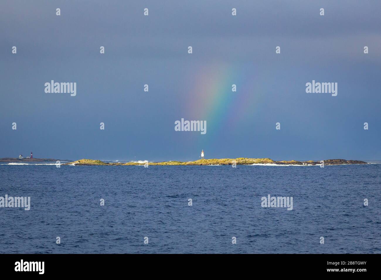 Sunbeam and rainbow over the lighthouse between Torvik and Ålesund on ...