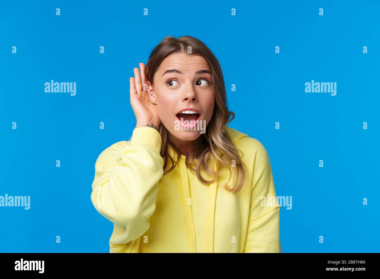 Close-up portrait of intrigued and curious blond young girl with ...