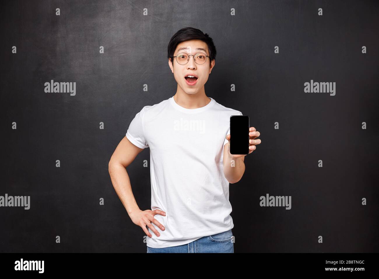 Technology, gadgets and people concept. Impressed and excited asian guy ...