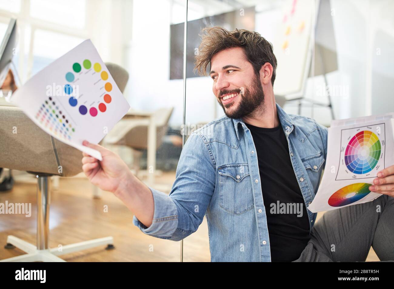 Creative graphic designer man with color wheel during color selection ...