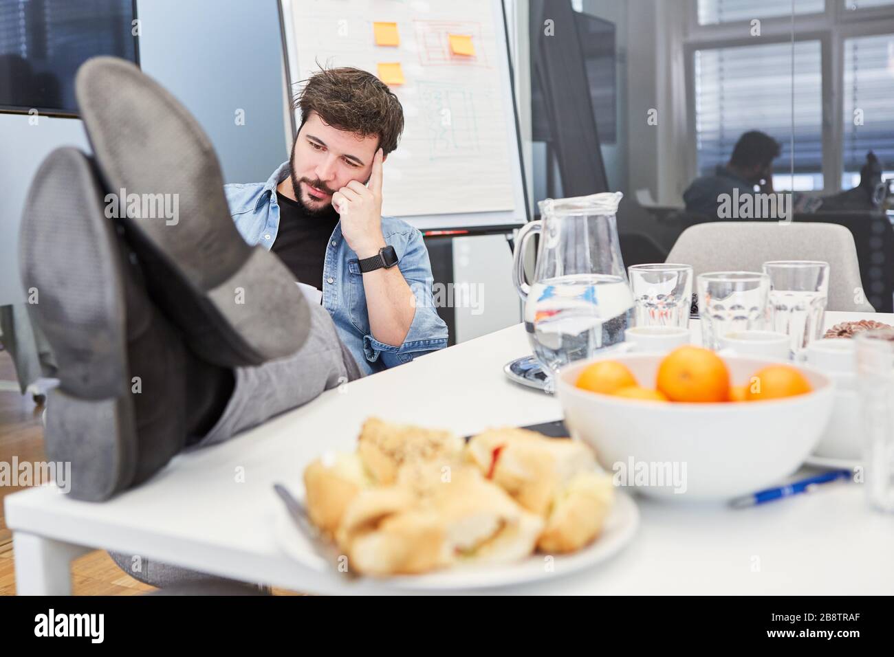 Business man relaxing in conference room with snacks and drinks on the ...