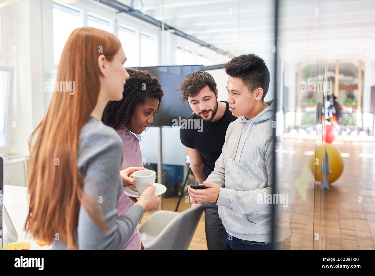 Young multicultural team at a meeting or a coffee break in the office ...