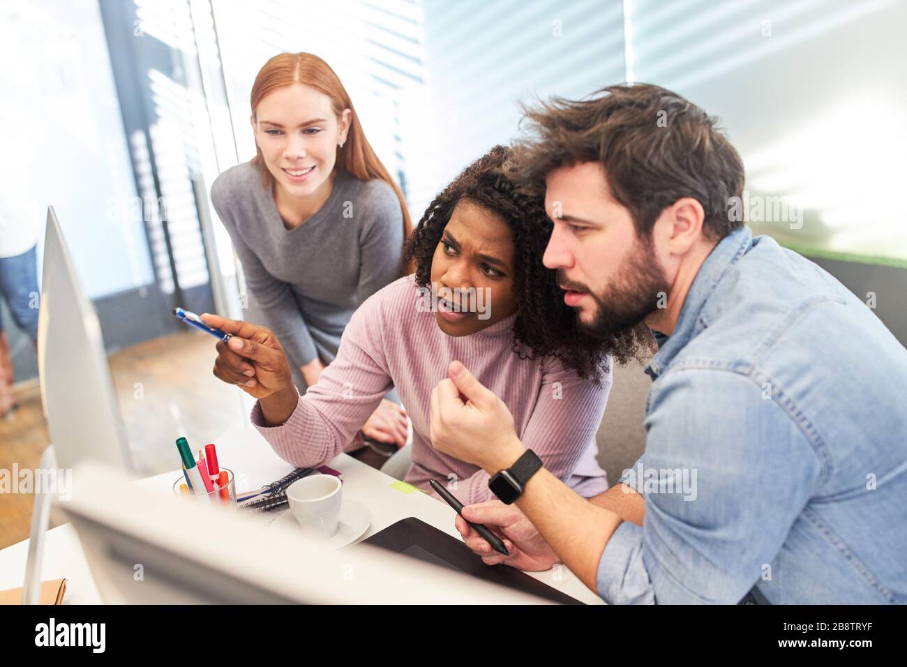 Creative web designer team on PC discusses a design for a new website ...