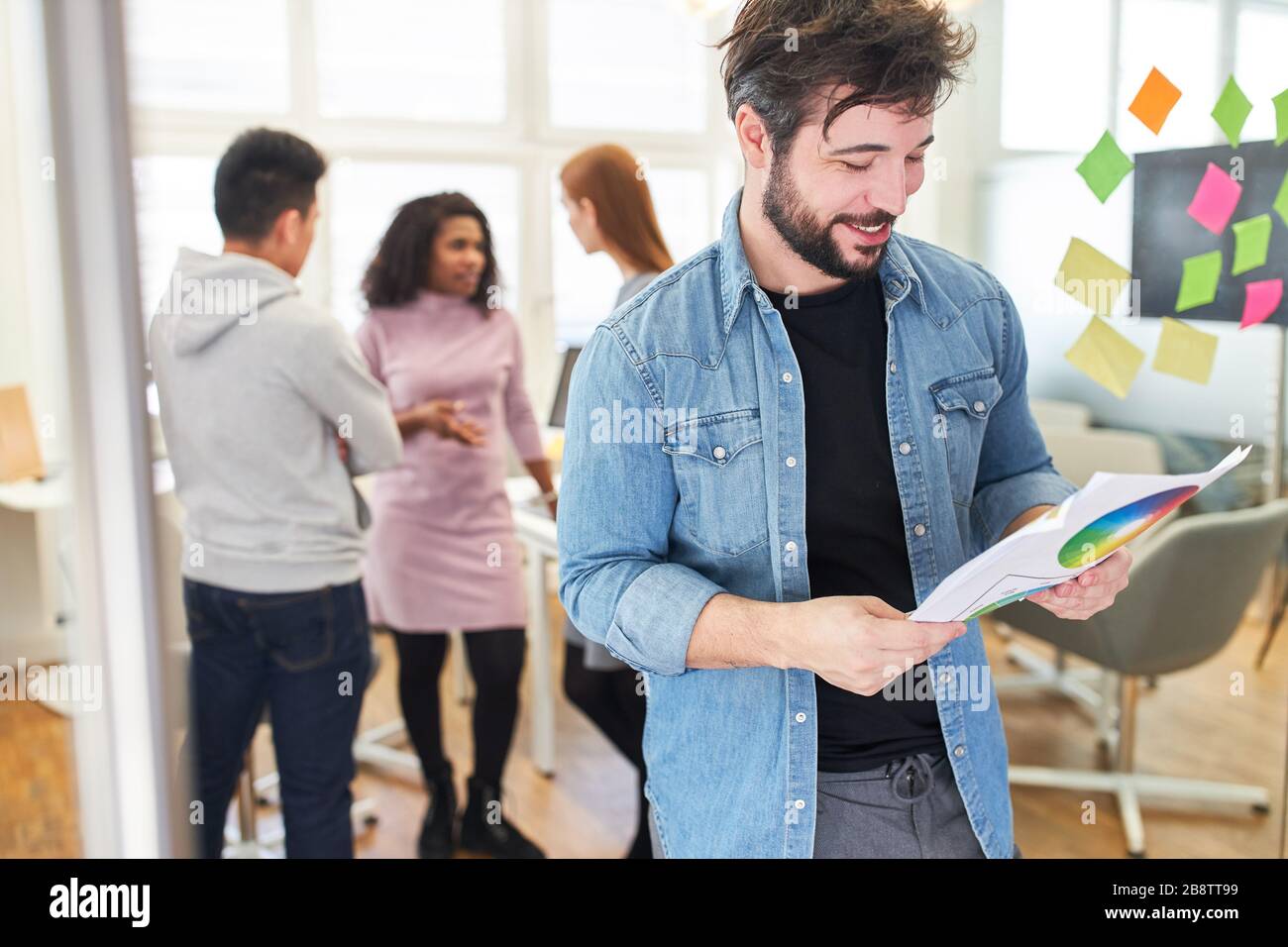 Graphic designer or programmer with color wheel in the office of an ...