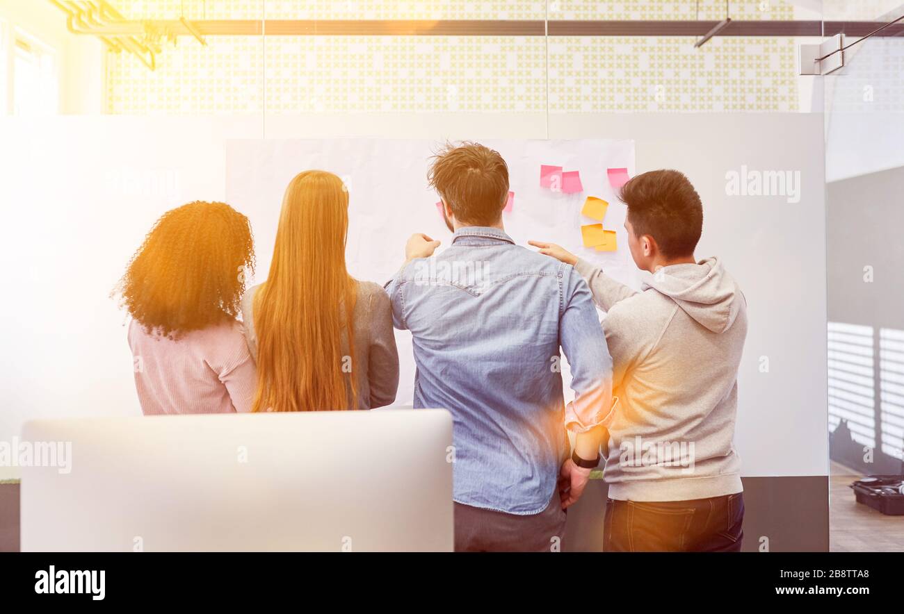 Brainstorming in team in the office with sticky notes on a whiteboard ...