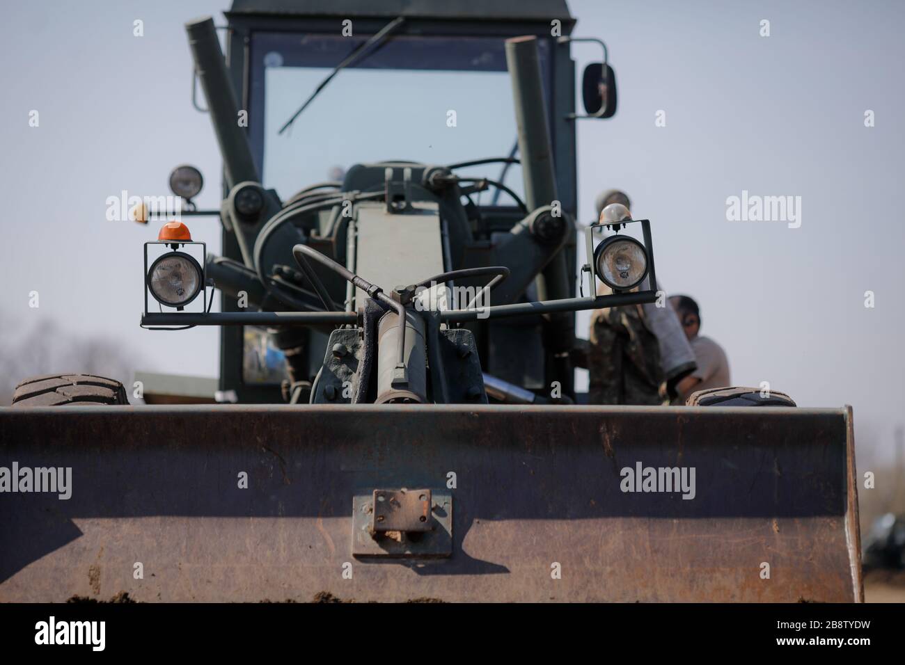 Details of an army tractor leveling the ground for a campaign mobile ...