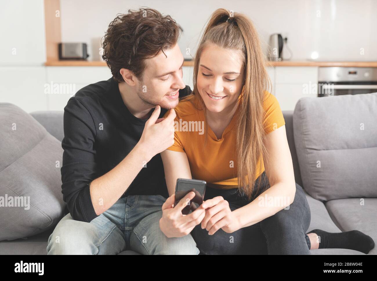 Couple using fast home internet with smart phone. Woman and man using ...