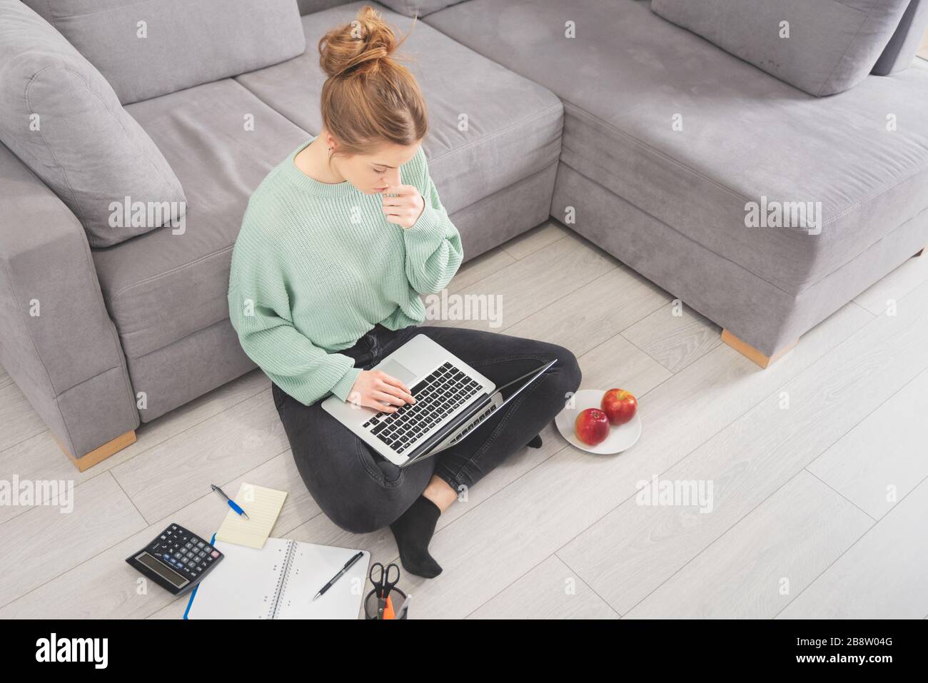 Young student learns at home on the floor. Studying, learning concept ...