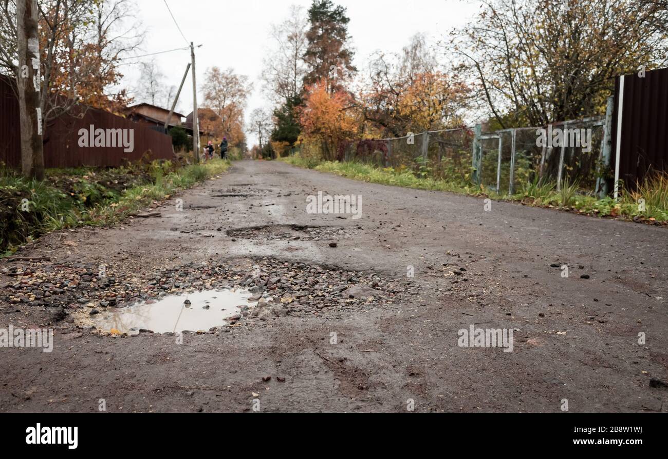 Dirty rural road with puddles and mud in autumn season, countryside ...