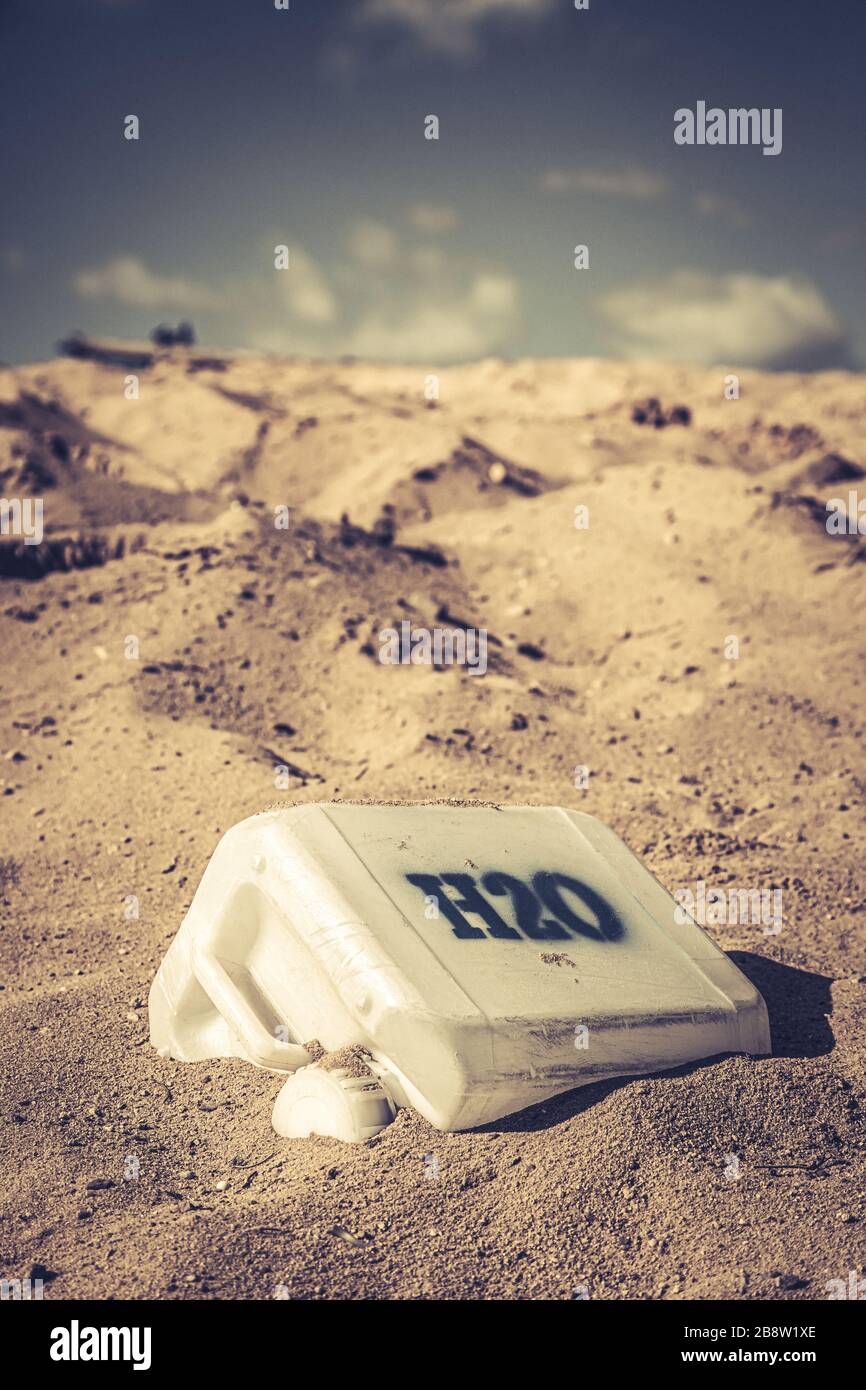 Empty water cans in the sunburned toxic desert Stock Photo - Alamy