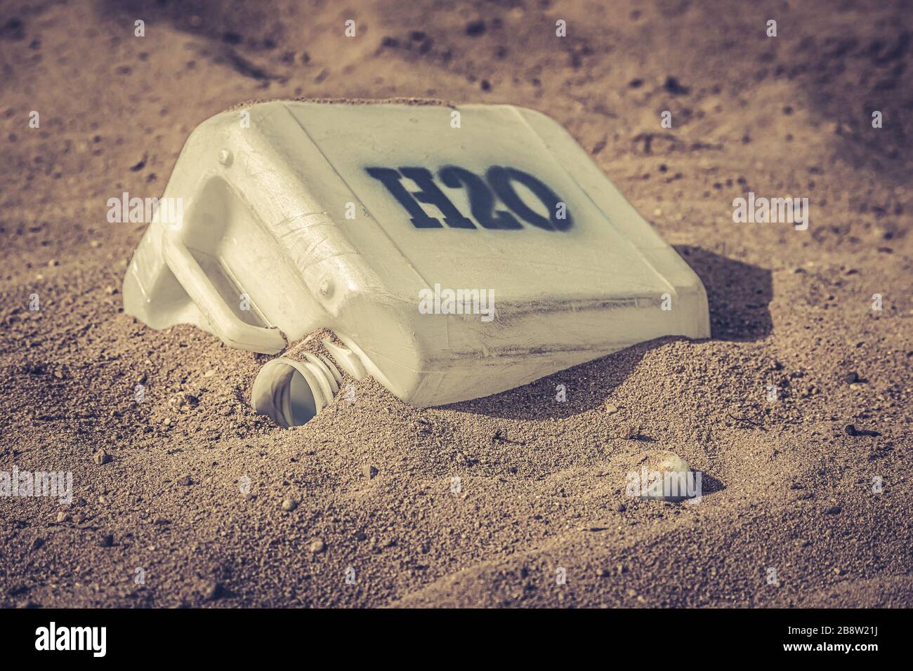 Unclean water cans in the sunburned toxic desert Stock Photo - Alamy