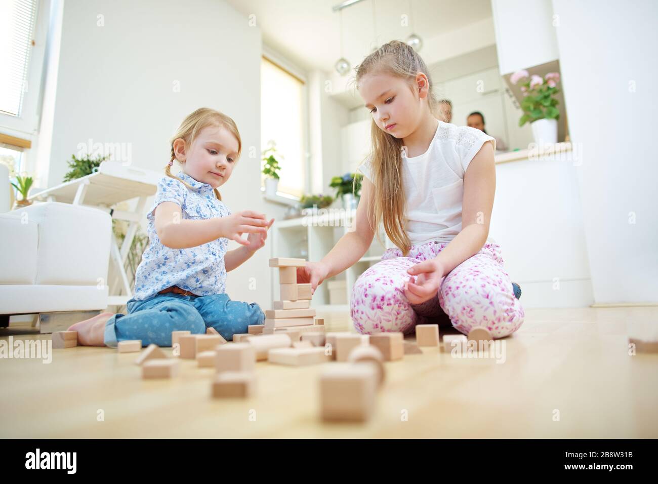 Two children build a tower of blocks together at home Stock Photo - Alamy