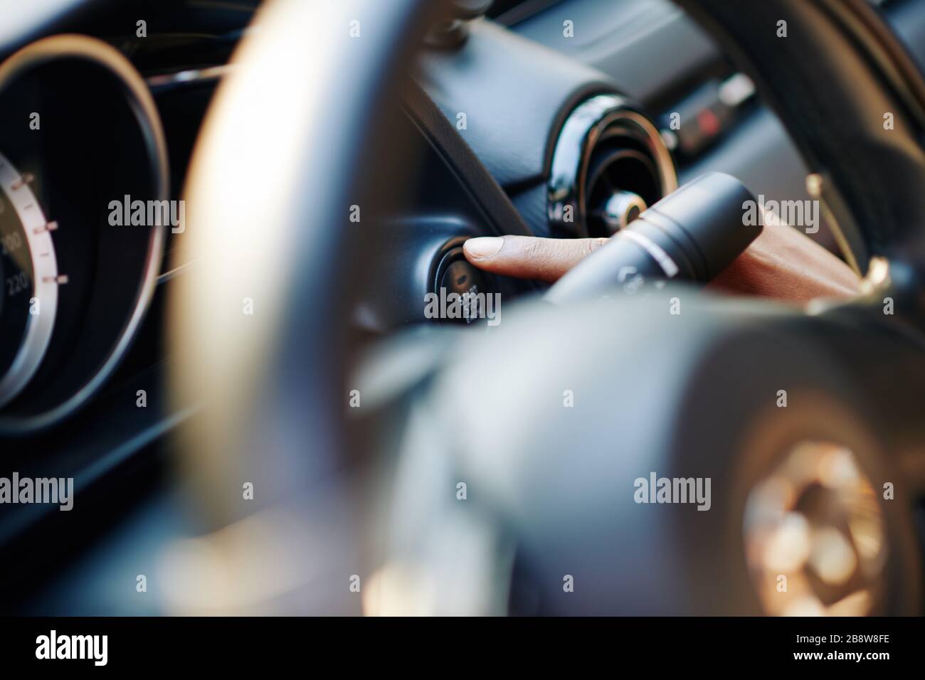 Close-up image of female driver pushing launch control button in modern ...