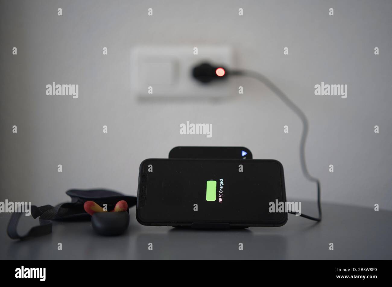 Black desktop wireless charger with charging led charging a smartphone ...