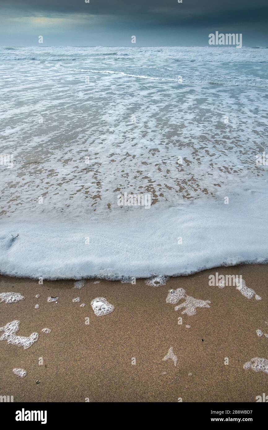 A gentle wave flowing on an incoming tide at a cold chilly windy ...