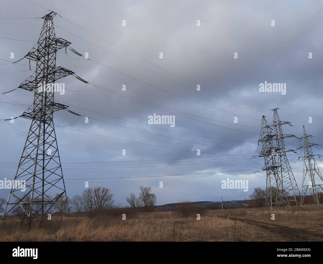 Metal pylons of a power line against a disturbing cloudy sky on the ...