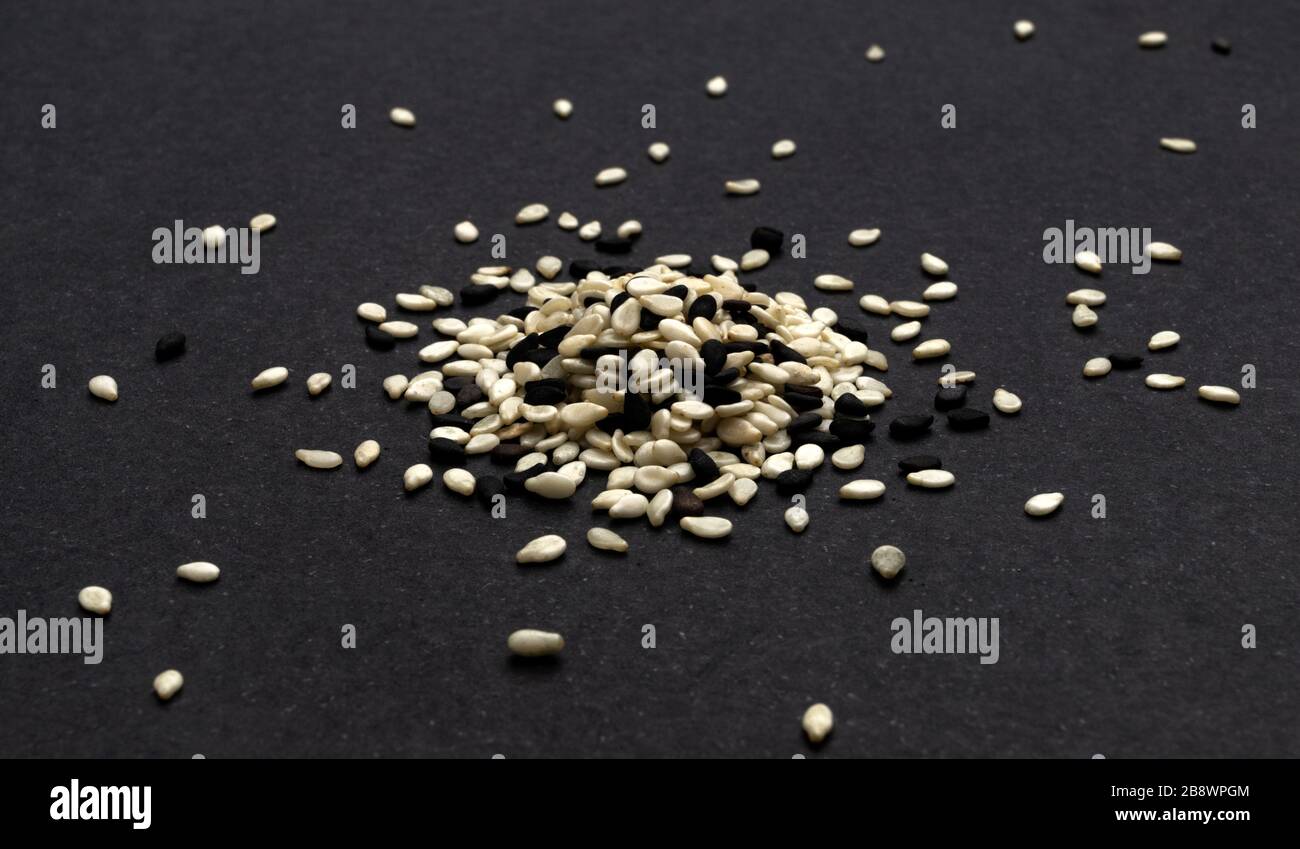 Black and white sesame seeds on black background, macro, close up Stock ...