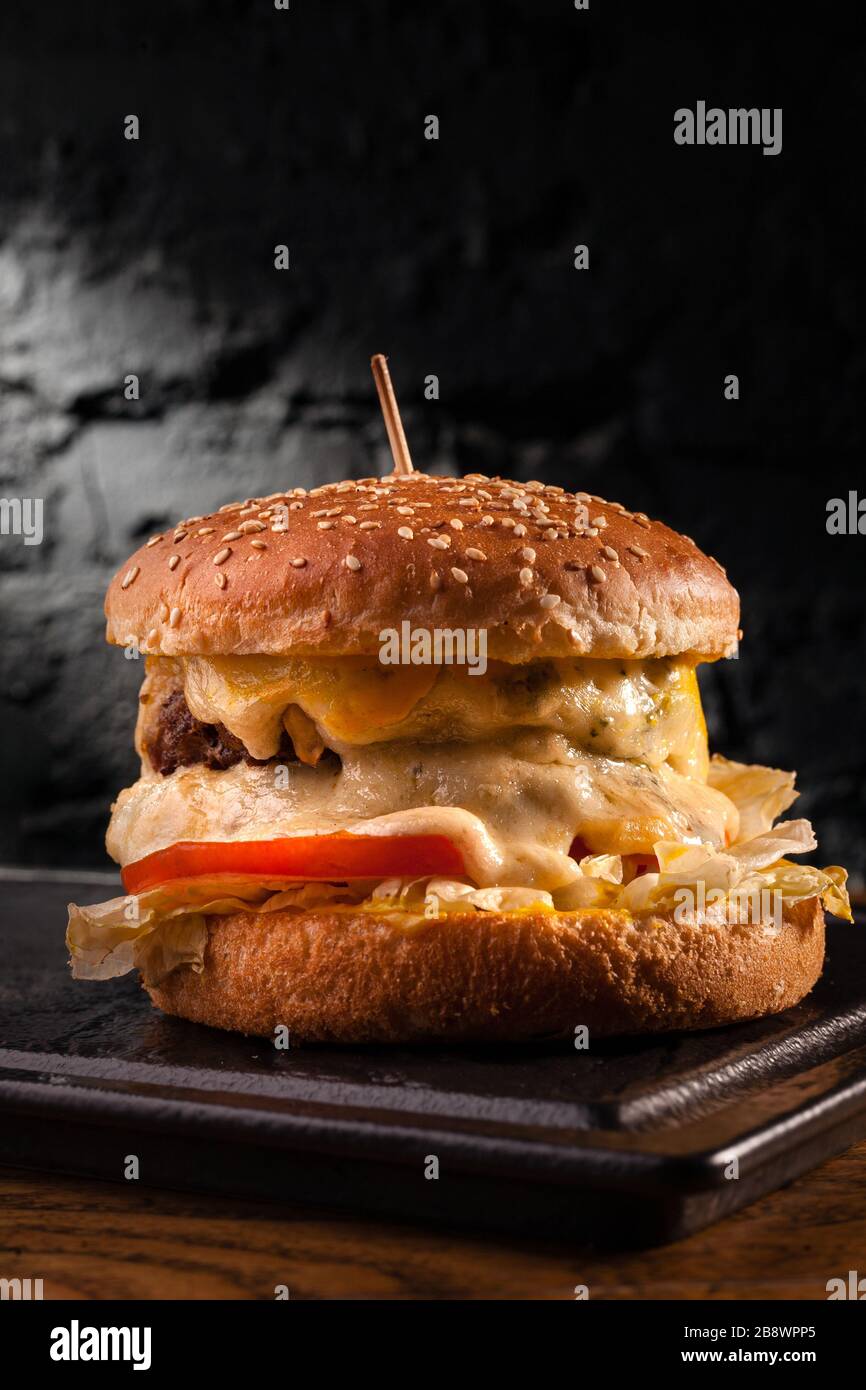 Big cheeseburger with lots of cheese. Stock photo side view of a ...
