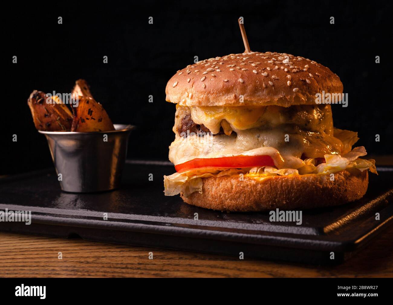 Big cheeseburger with lots of cheese. Stock photo side view of a ...