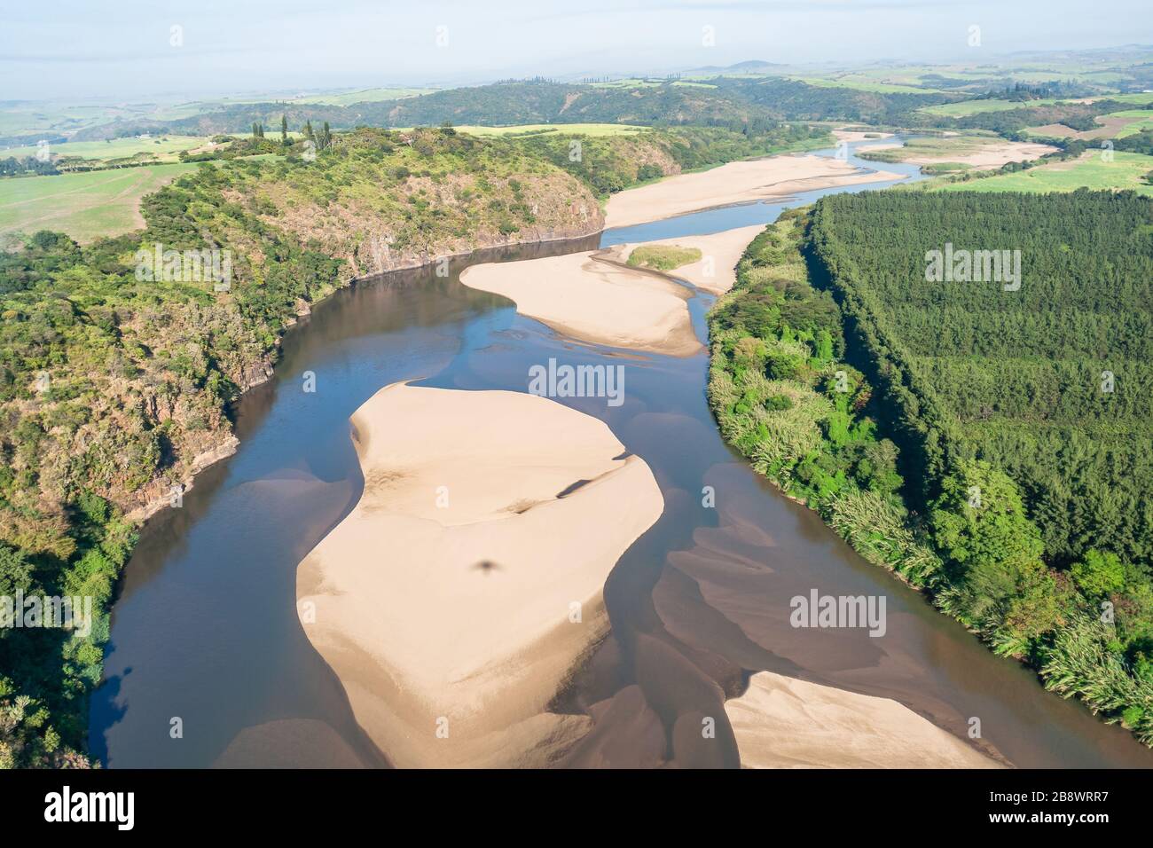 Flying aerial view down large wide river overhead with low water ...