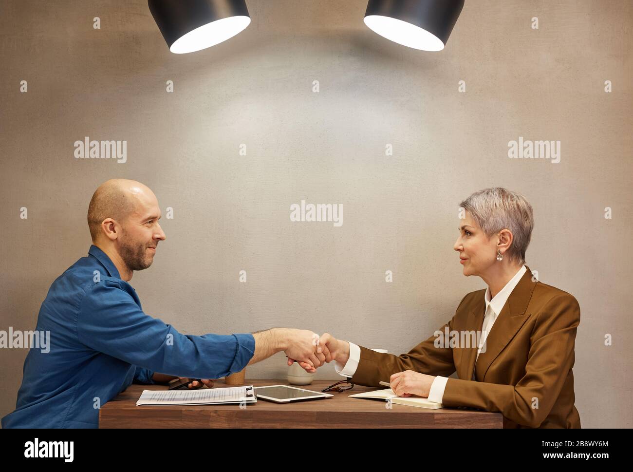 Handshake across table hi-res stock photography and images - Alamy
