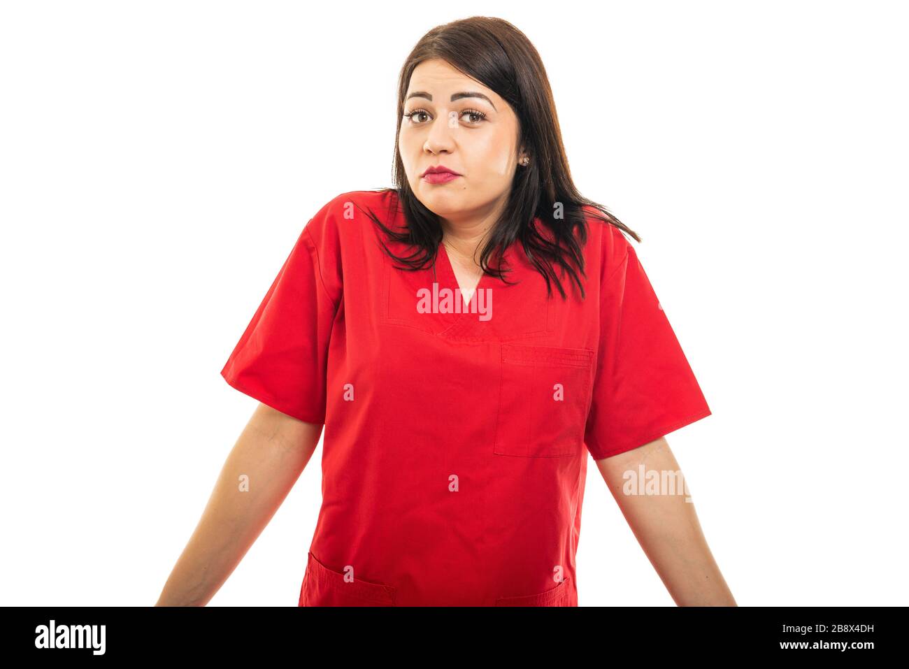 Portrait of beautiful doctor wearing scrubs making not knowing gesture ...