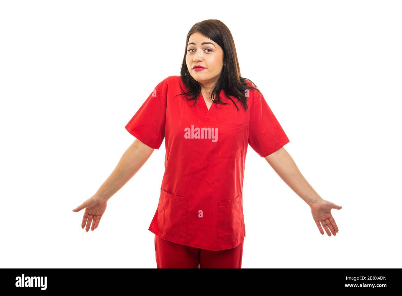 Portrait of beautiful doctor wearing scrubs making not knowing gesture ...