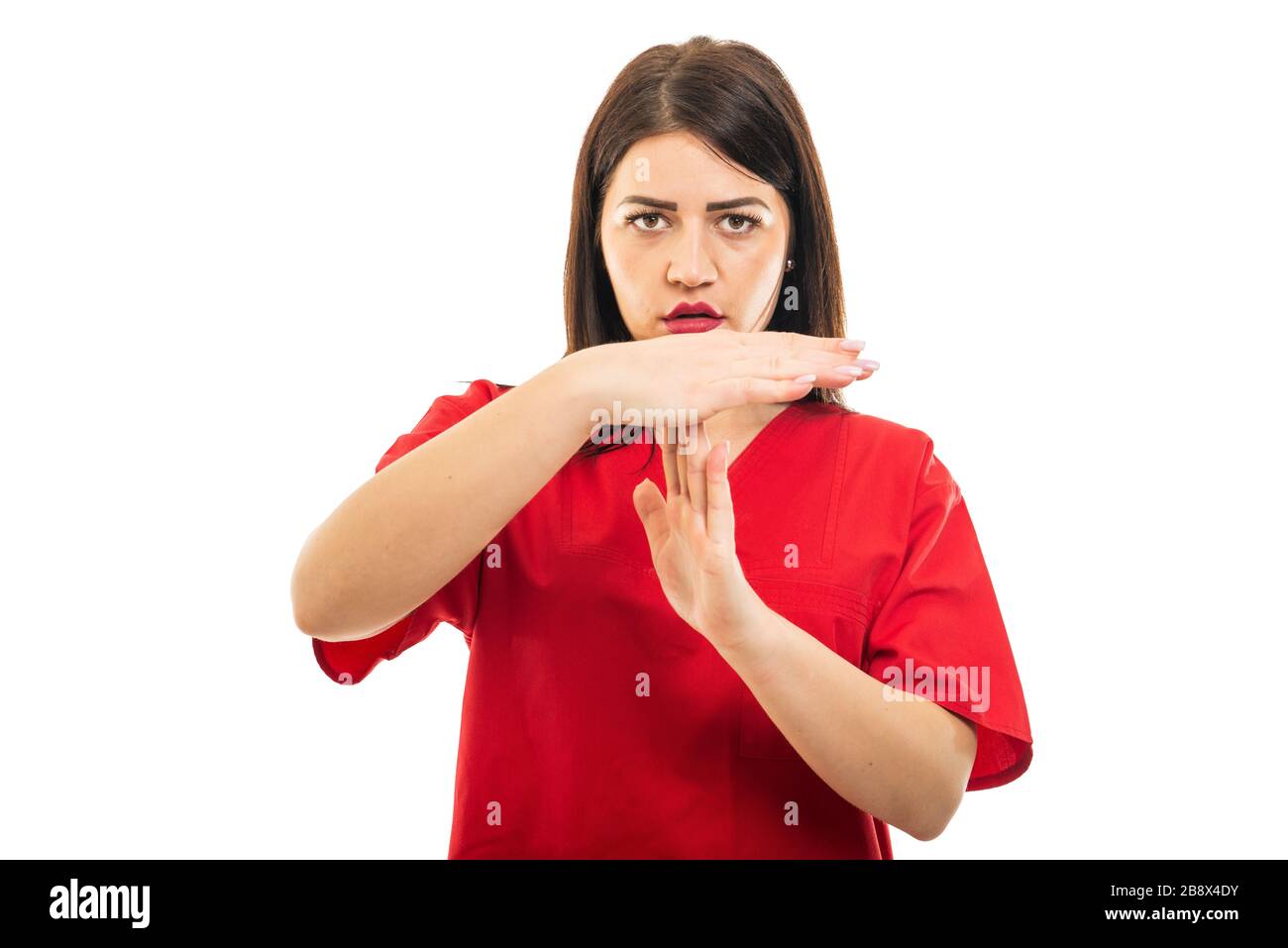 Portrait of beautiful doctor wearing scrubs making time out gesture ...
