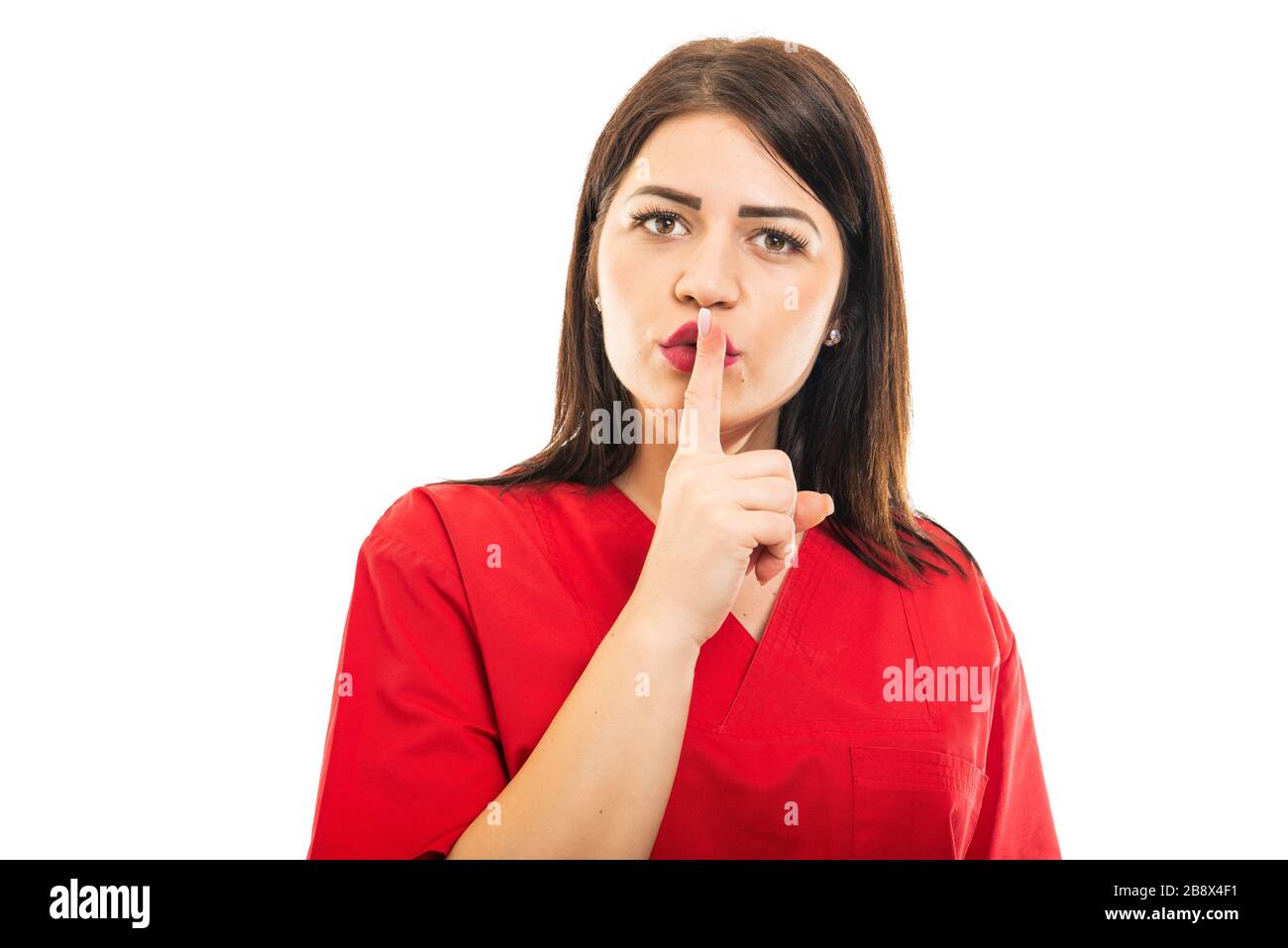 Portrait of doctor wearing scrubs making silence gesture isolated on ...