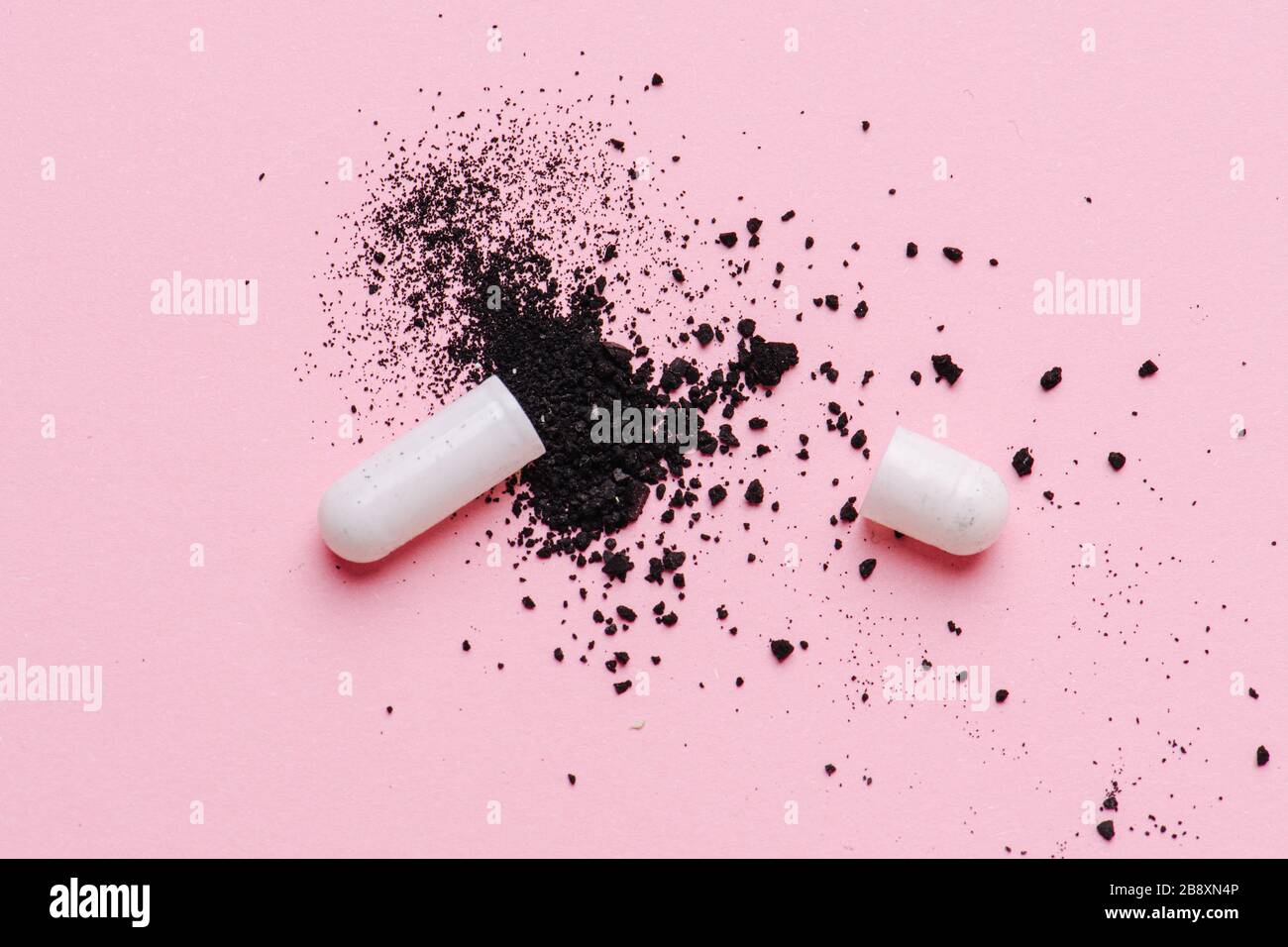 Open drug capsule causes black ingredient to splash over nearby surface ...