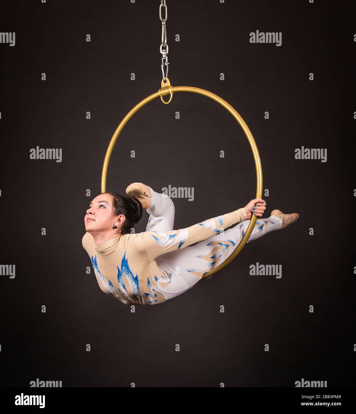 A slender,dark-haired woman - an air acrobat in a white and blue suit ...