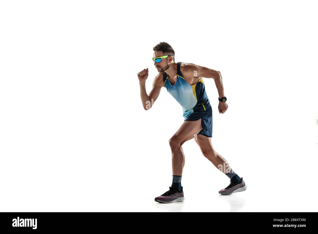 Triathlon male athlete running isolated on white studio background ...