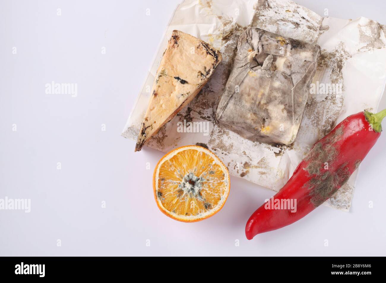 Spoiled rotten foods with mold: orange, pepper, hard cheese and butter ...