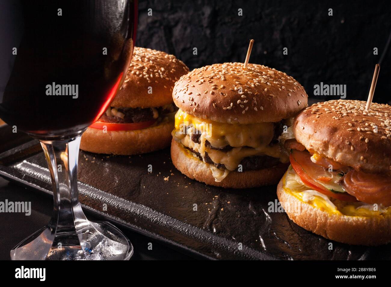 Cold beer in a glass and a snack in the form of juicy large burgers ...