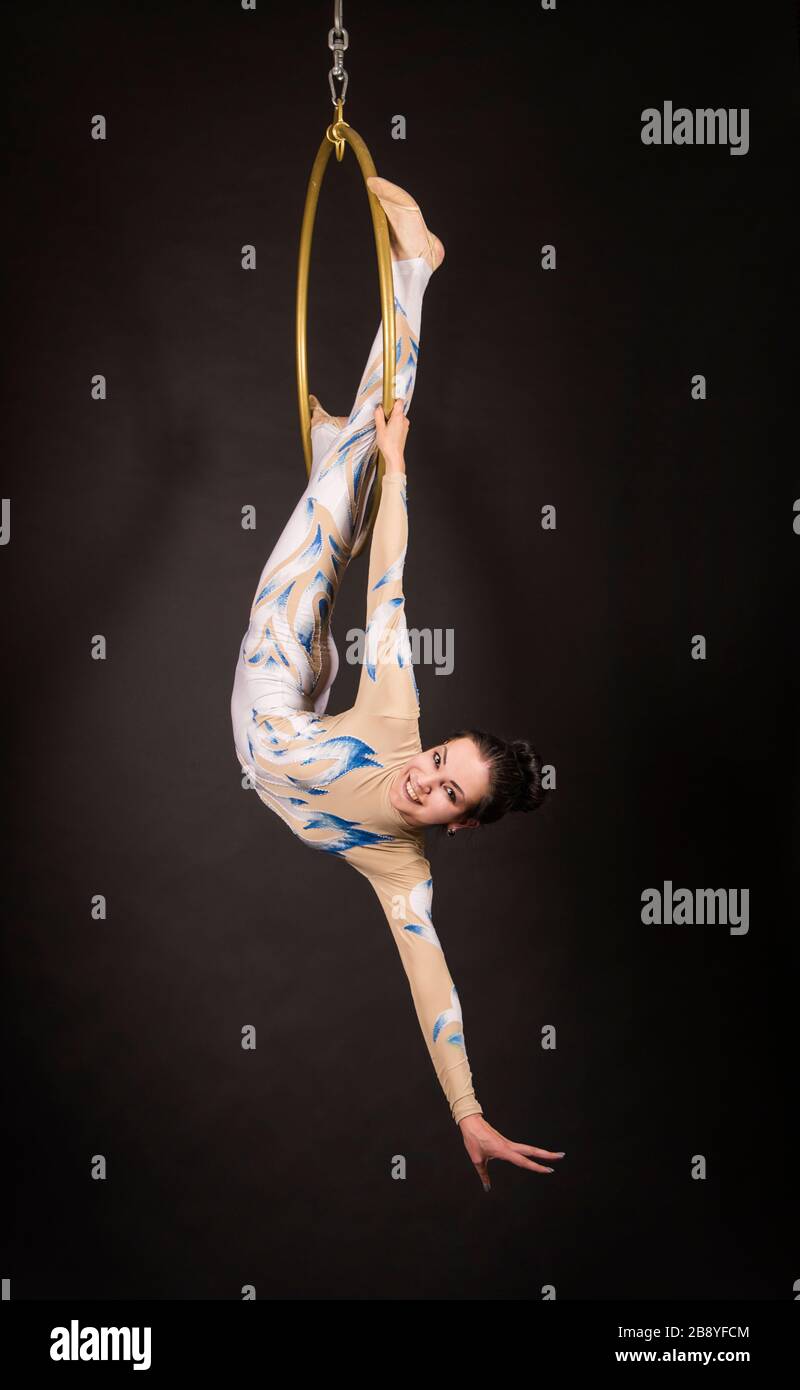 A slender,dark-haired woman - an air acrobat in a white and blue suit ...