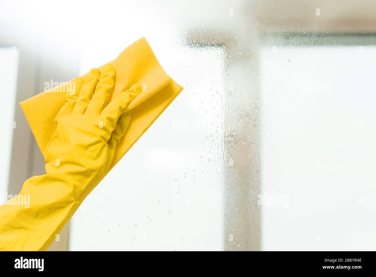 Cleaning windows with special rag. Hands with spray cleaning the window ...