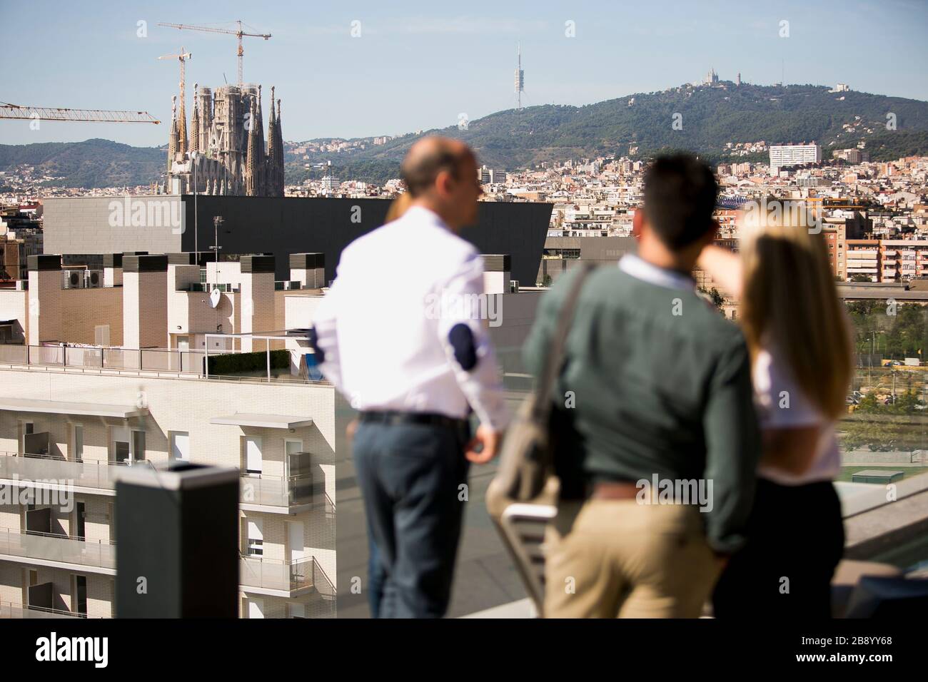 People on a rooftop watching La Sagrada Familia Stock Photo - Alamy