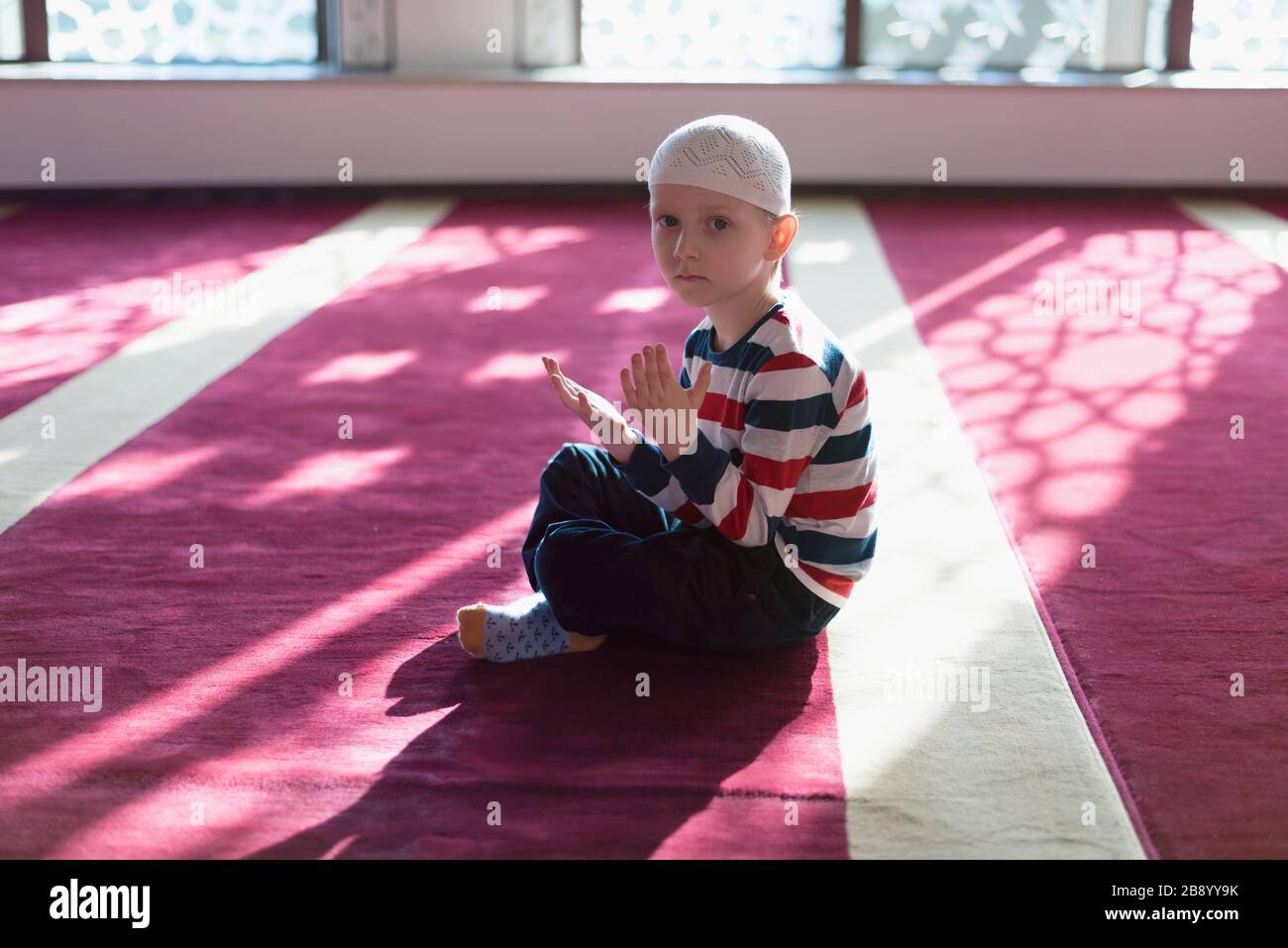 Ramadan Kareem,beautiful boy Muslim is praying in mosque,Peace and love ...