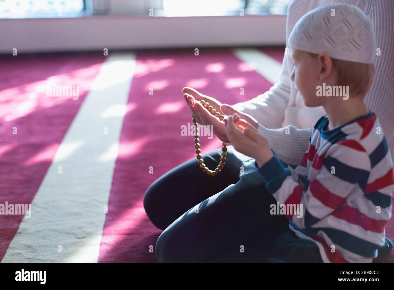 Muslim father and son praying together. Muslim dad and son praying in ...