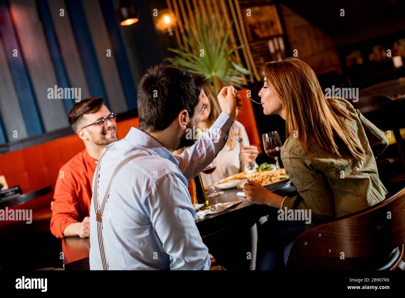 Group of young people having dinner in the restaurant Stock Photo - Alamy