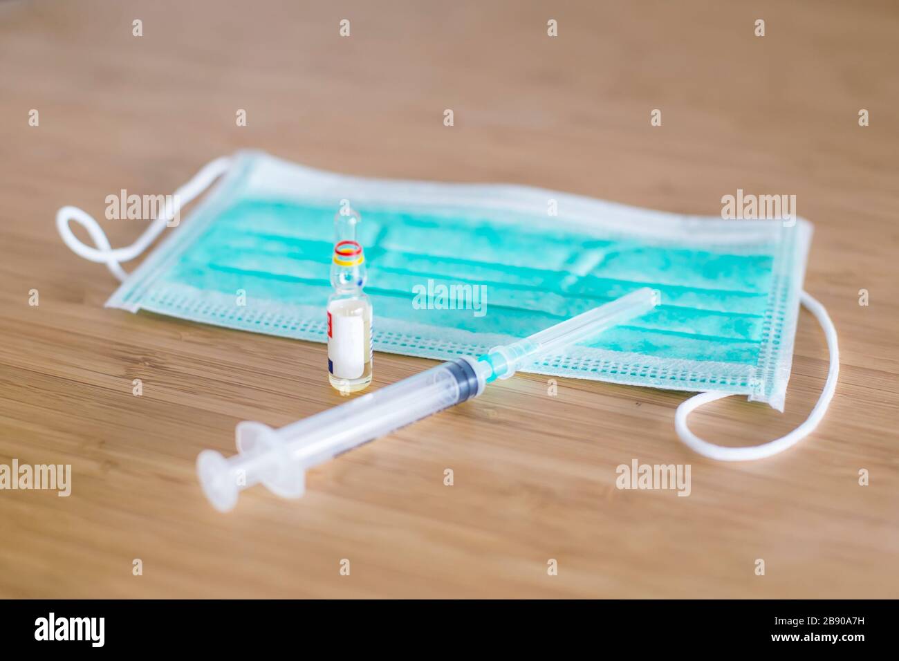 Surgical ear-loop mask and injection syringe on the table Stock Photo ...