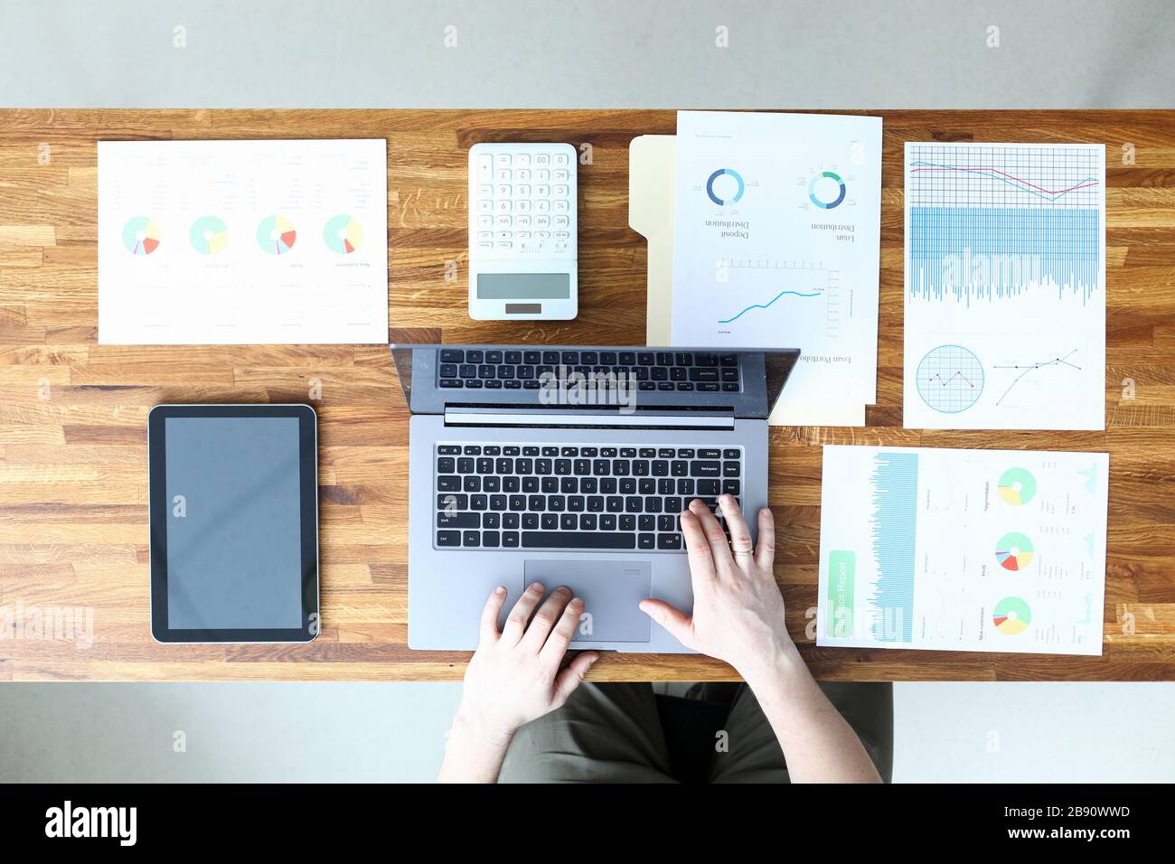 Man in office enters data from report into laptop Stock Photo - Alamy