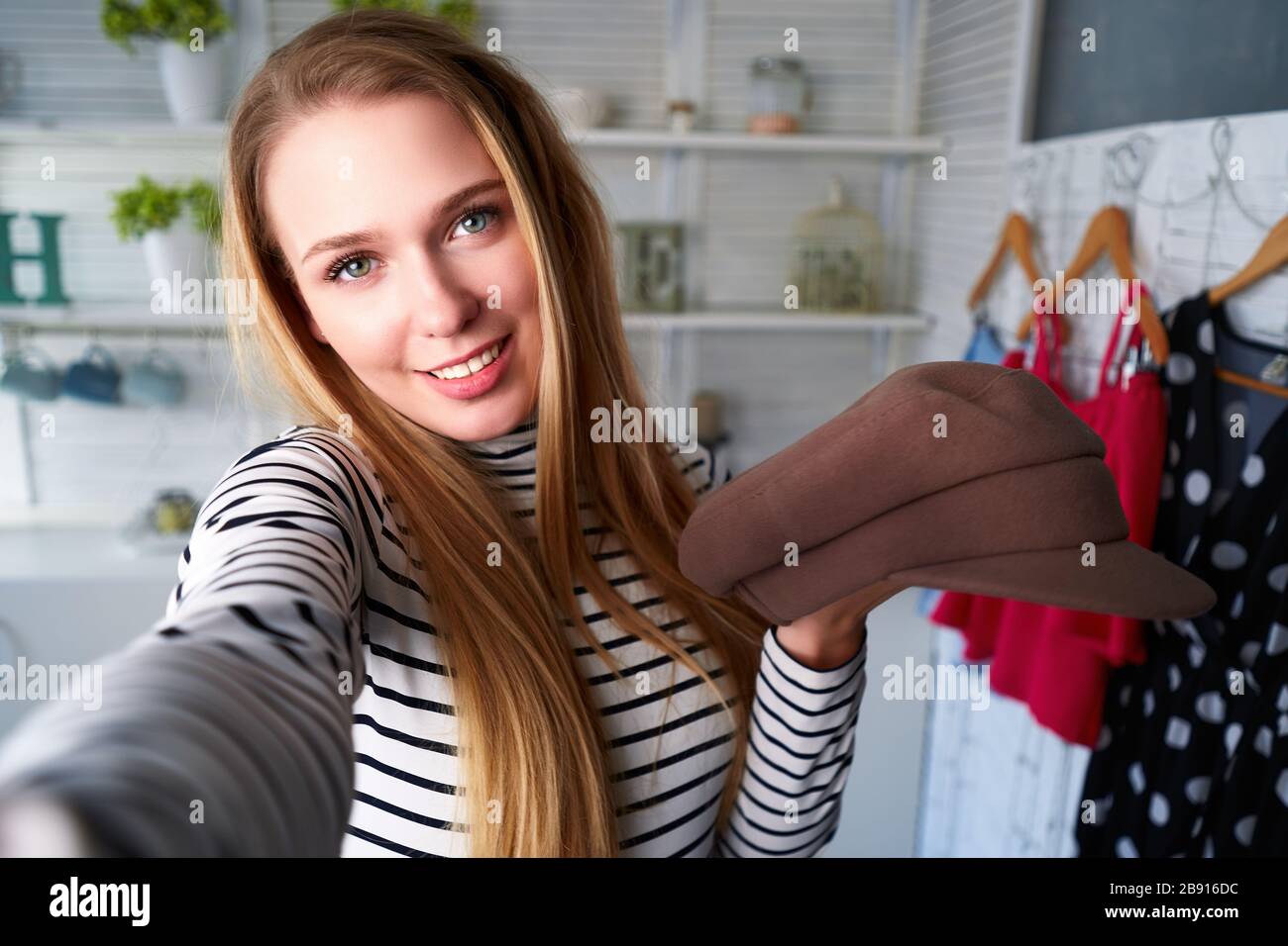 Fashion blogger woman in jeans and turtleneck showing fashionable caps ...