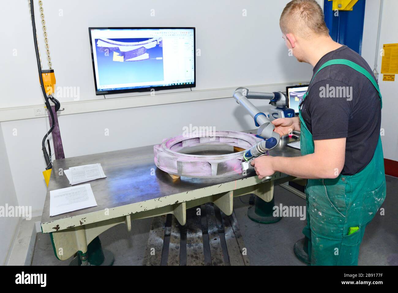 quality control - workers at a measuring station to check the ...