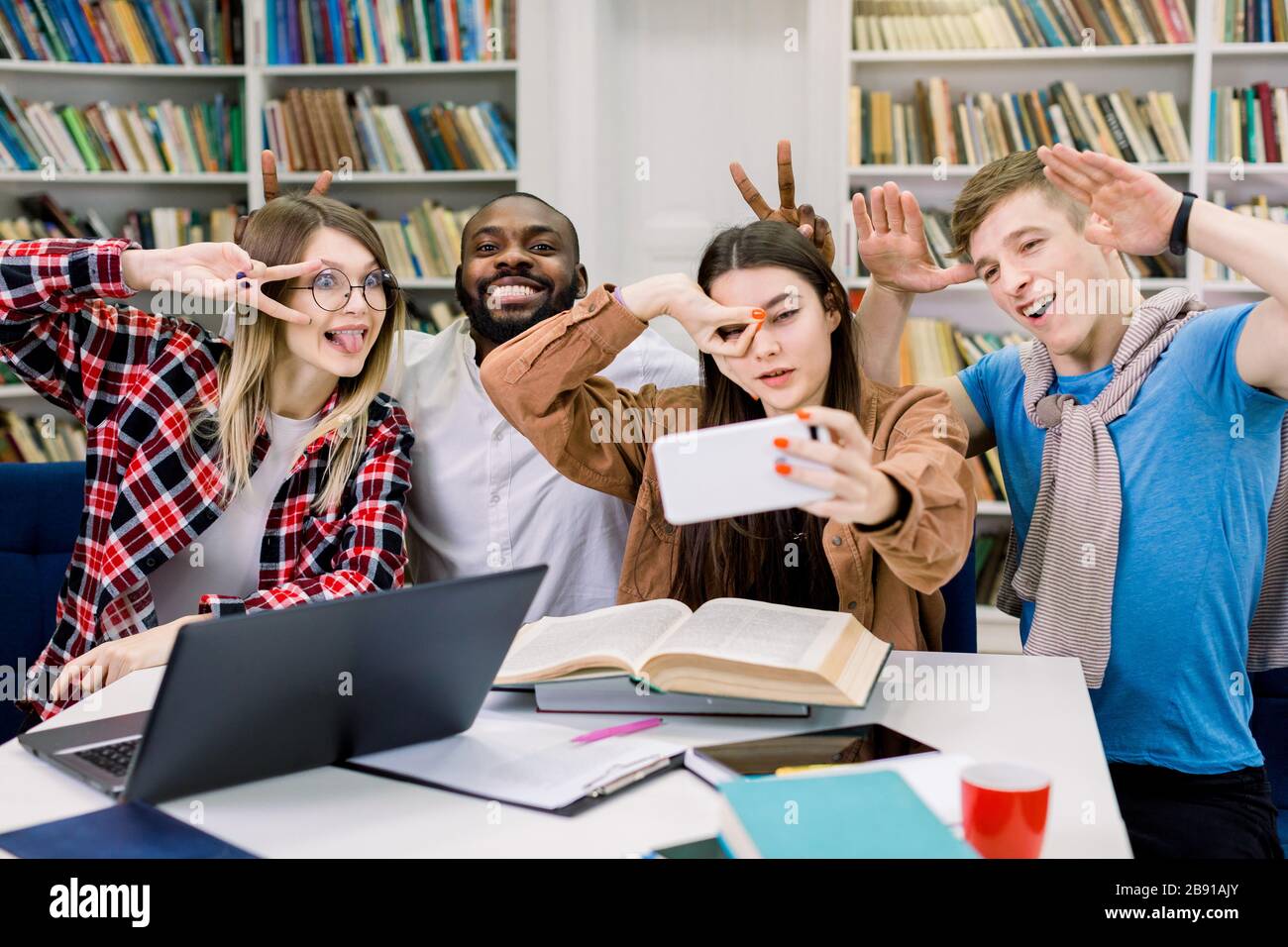 Selfie time in library. Four cheerful, smart and successful ...