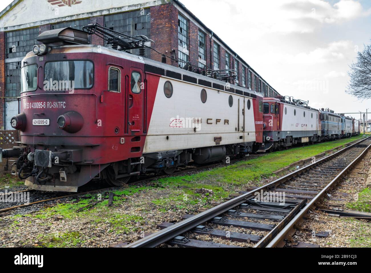 Multiple Red and white diesel locomotives in a row. Railroad in front ...