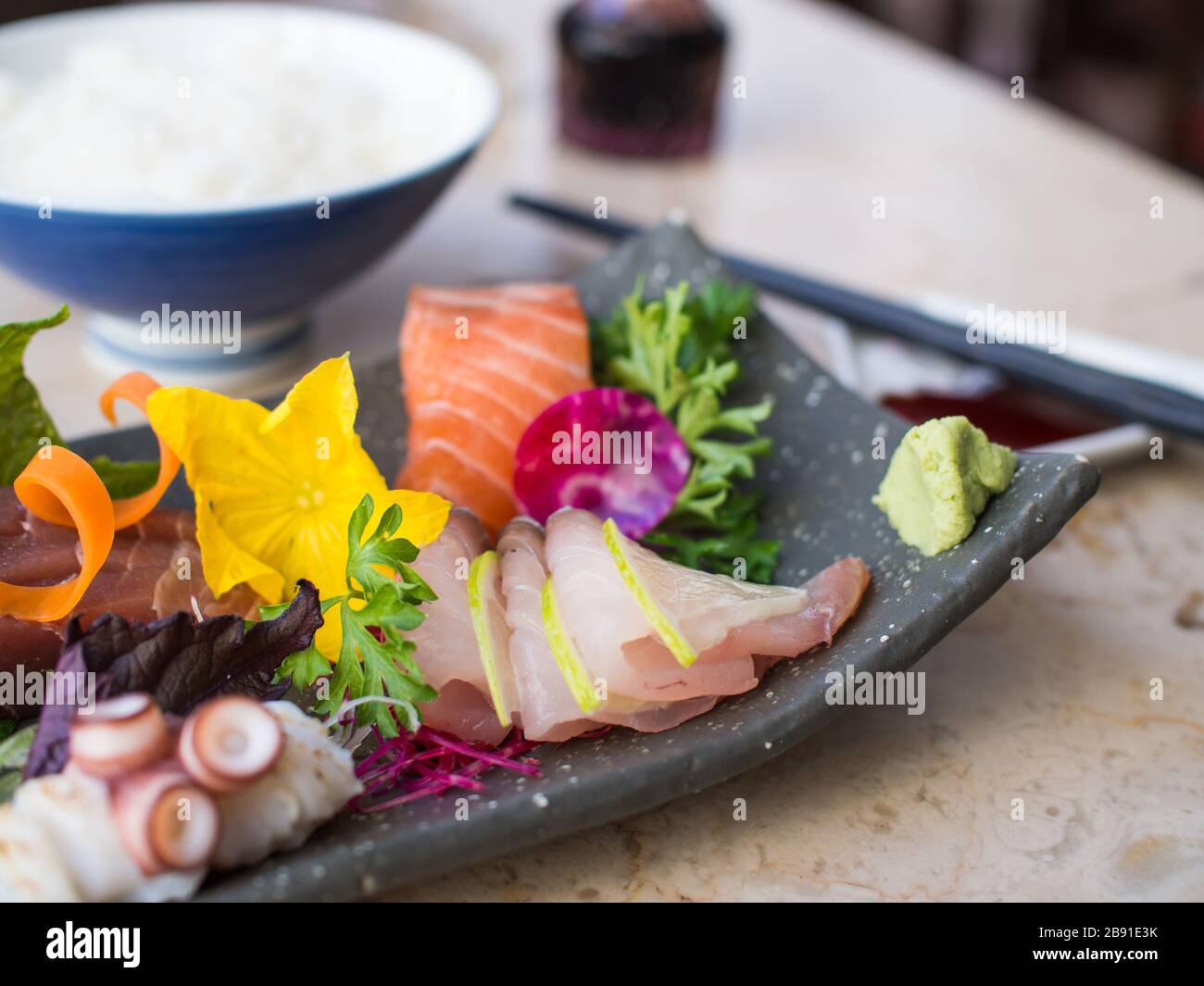 Japanese raw fish on black plate. Also known as Sashimi Stock Photo - Alamy